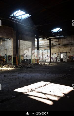 A view of an abandoned factory in a field during sunset Stock Photo - Alamy