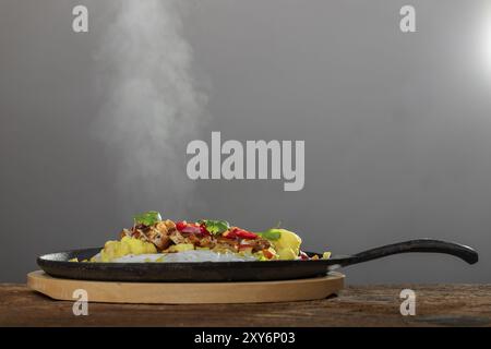 Steaming hot sizzler on wood Stock Photo - Alamy