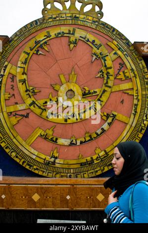 Egyptian college students walking by a colorful decorated wall in ...