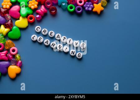 A collection of colorful beads is spread out across a blue background ...