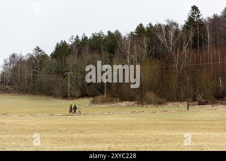 Small group of people walking across a field Stock Photo - Alamy