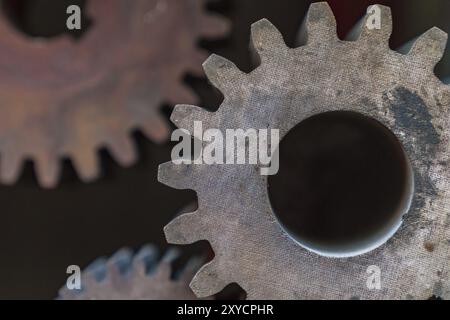 Interlocking gear wheels in front of a black wall Stock Photo - Alamy