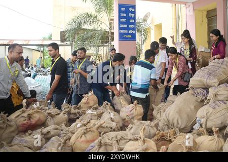 Government officials and workers are preparing food packets to be ...