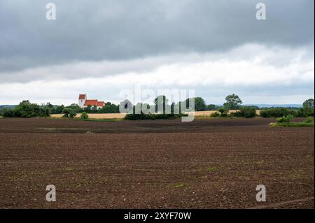 Brown soil and dark clouds at the Danish countryside around Skibinge ...