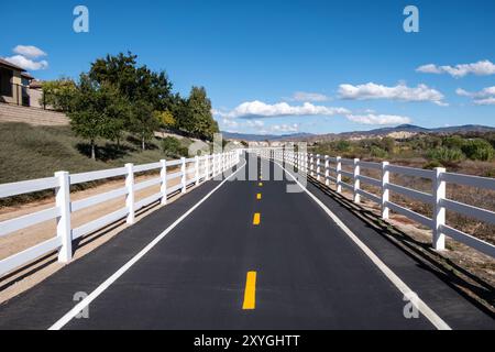 Suburban bike path with white fencing entertaining wiggles along the ...