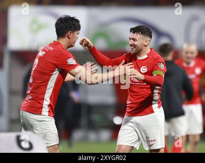 Larne's Tomas Cosgrove (second right) celebrates scoring their side's ...