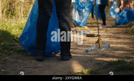 Diverse activists group using claw tools to grab trash and plastic ...