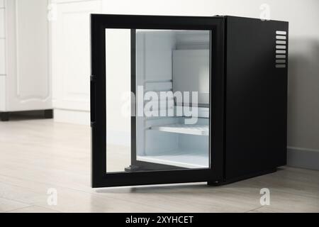 Empty modern mini refrigerator near white wall Stock Photo - Alamy