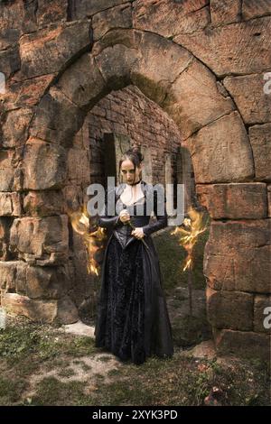 A game with the fire of a young gothic lady with dagger playing with ...