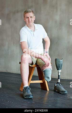 Portrait of disabled man with prosthetic leg standing outside with ...