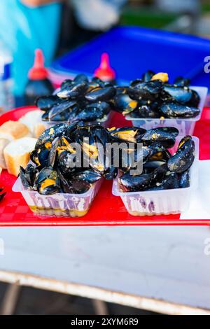 Close-up of 6 mussels servings on a red tray at 2024 "Poissonade ...