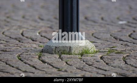 Cobblestone and the stone base of a steel pole Stock Photo - Alamy
