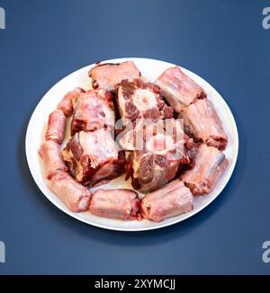 Raw beef oxtail on a round white plate in closeup Stock Photo - Alamy