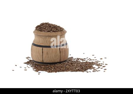 Linseed in small wooden barrel near bunch of flax plants and wooden scoop isolated on white ...