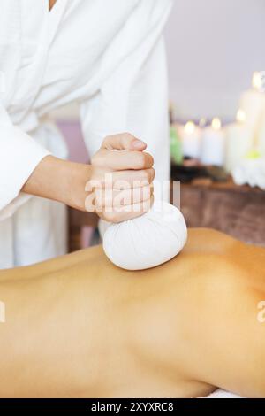 Woman having massage with pouch of rice Stock Photo - Alamy