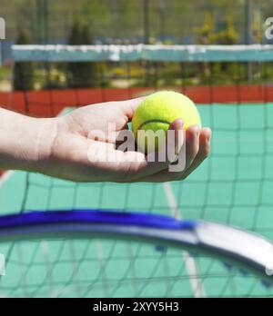 Tennis racquet and tennis ball in hands of man Stock Photo - Alamy