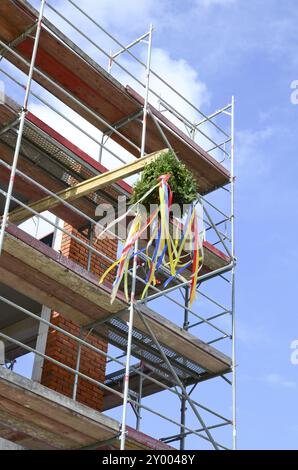 construction worker at topping out or roofing ceremony, when finishing ...