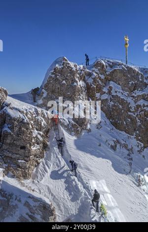 Climbers at the cross on the summit of Zugspitze Mountain, the highest ...