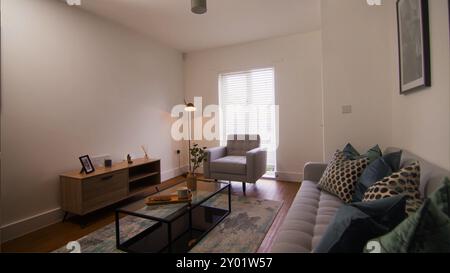 Chest of drawers with decor, coffee table and pouf near white brick ...