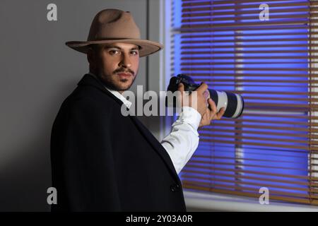 Male detective taking pictures near window in room at night Stock Photo ...