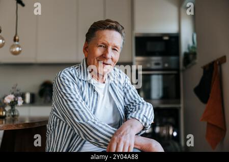 Joyous man in striped t-shirt smiling and showing thumb up while taking ...