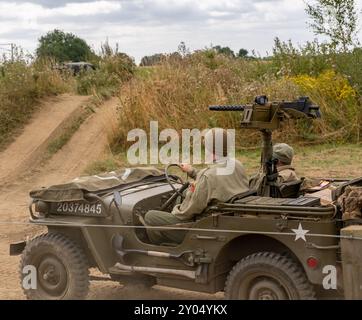 Two young men dressed as soldiers driving around in a military jeep on ...