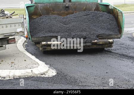 Fresh new pile of asphalt in surfacing road machine Stock Photo - Alamy