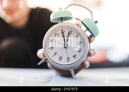 Sleepy guy holding alarm clock being in bed in morning, time Stock ...