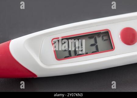 Red fever thermometer with digital display and pills lying on the desk ...