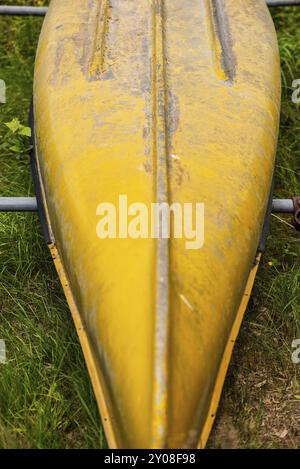 Yellow canoe lying upside down Stock Photo - Alamy