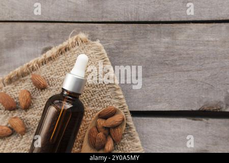 Almond essential oil in glass bottle with green leaf. Cosmetic concept ...