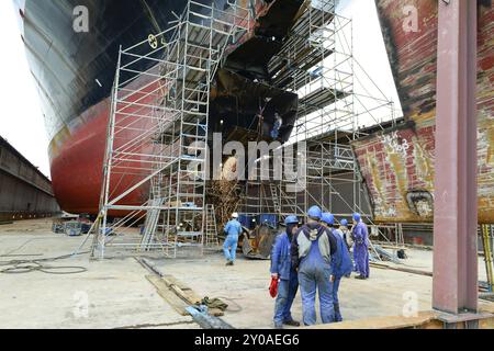 Welding and cutting work on a ship's hull in dockyard. Welding and ...