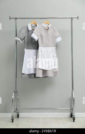 Maids' uniforms on clothing rack against grey background Stock Photo ...