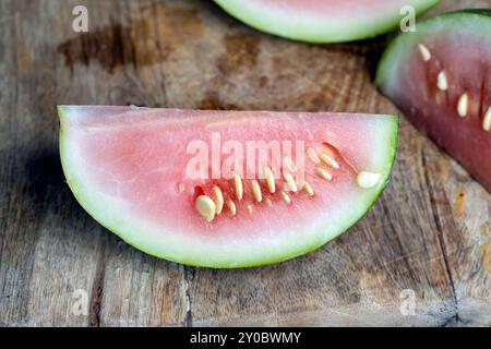 Unripe watermelon of small size with large white seeds and light pink ...