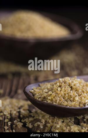 Raw Bulgur (on wooden background) as detailed close-up shot Stock Photo ...