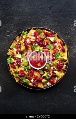 Nachos chips with sauces on black plate Stock Photo - Alamy