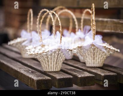 Small white wicker baskets with white ribbons stand on a bench Stock ...