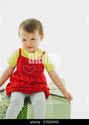 Child with gift present box on isolated studio background. Gifting for ...