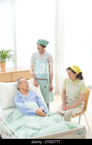 An elderly in bed and a care helper Stock Photo - Alamy