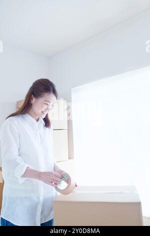 A woman busy packing for a move with a smile on her face Stock Photo ...