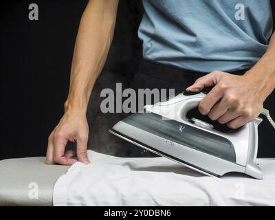 Male person using a steaming hot iron Stock Photo - Alamy