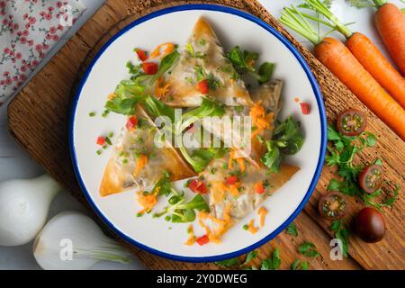 Baked brick pastry triangles filled with eggplant. Top view table with ...