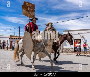 Gauchos in traditional outfits riding on horseback in a parade in Cachi ...