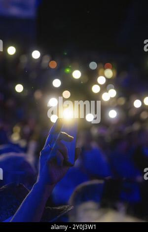 People shine the lights of their mobile phones during a protest outside ...