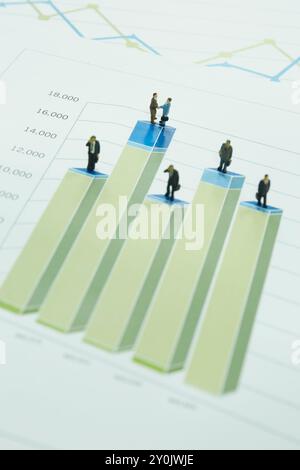 Numerous salaryman dolls standing on top of a bar graph Stock Photo - Alamy