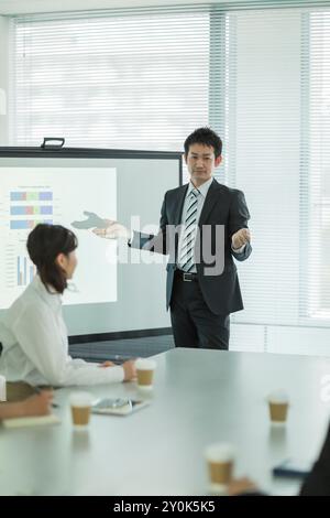The businessman who explains at the meeting which uses a projector ...