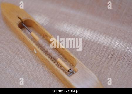 Woven textile and shuttle in the process of weaving Stock Photo - Alamy