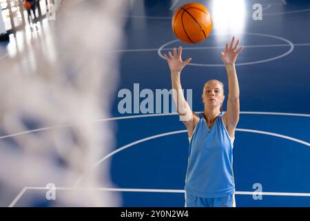 Woman shooting basketball on court Stock Photo - Alamy