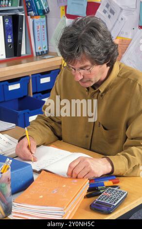 Teacher Marking Books Stock Photo - Alamy