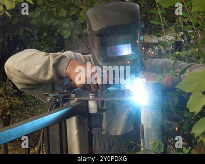 unrecognized man welding a metal gate in countryside yard Stock Photo ...